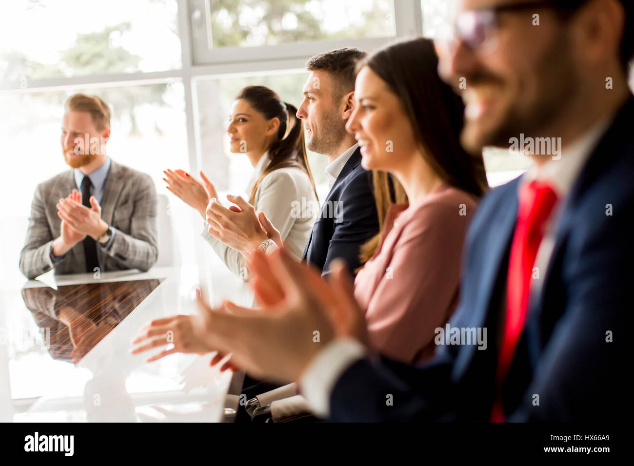 Smiling business group clapping hands at the meeting Stock Photo - Alamy