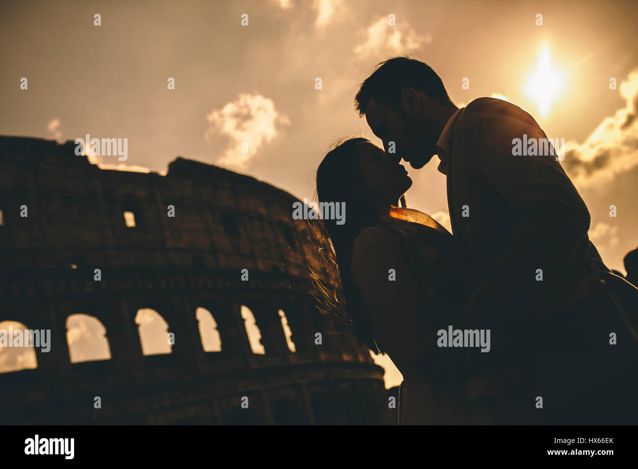 Young couple in love in front of the Colosseum in Rome at sunset Stock ...