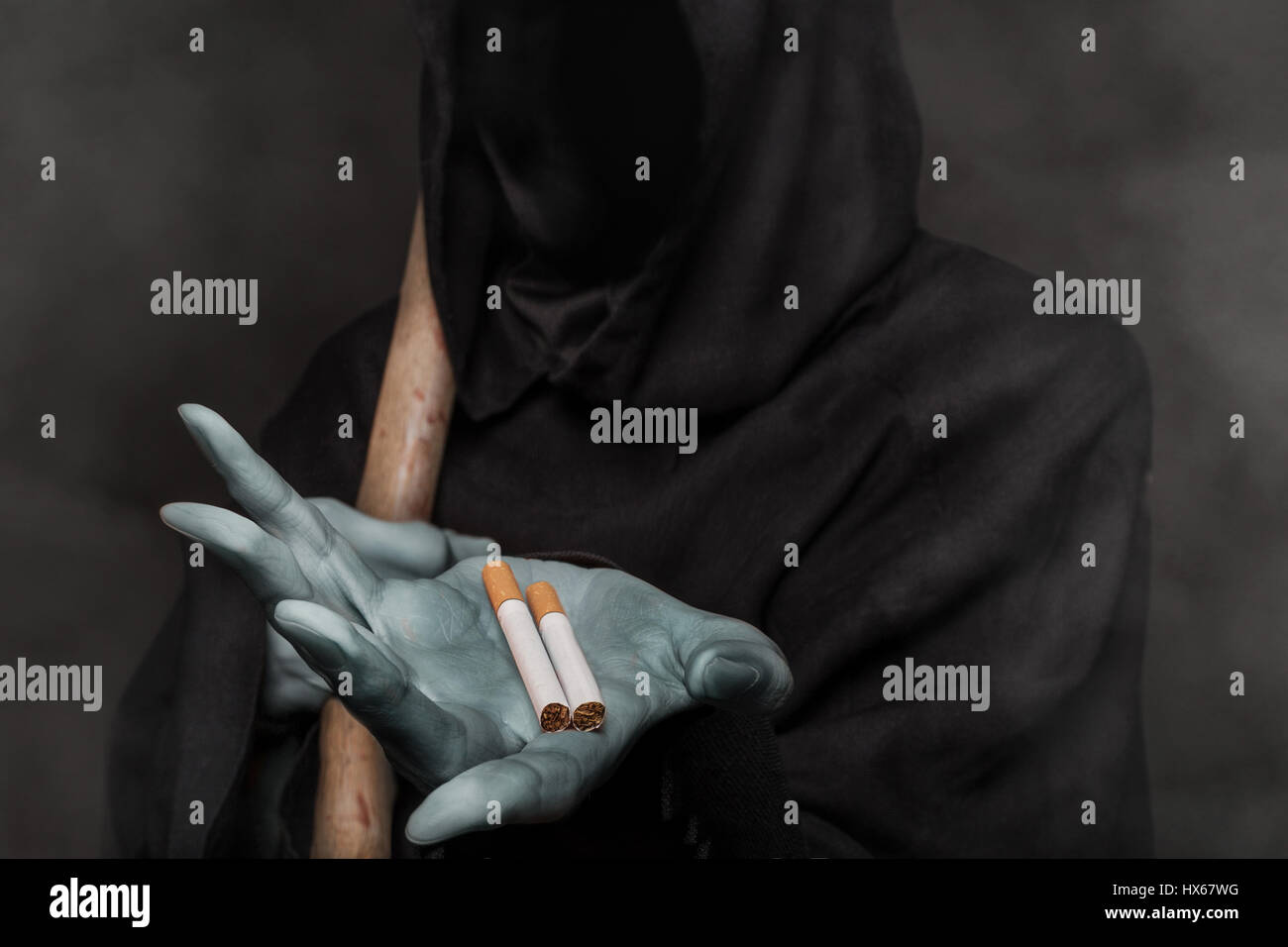 The concept: smoking kills. Grim reaper holding cigarette. Studio shot ...