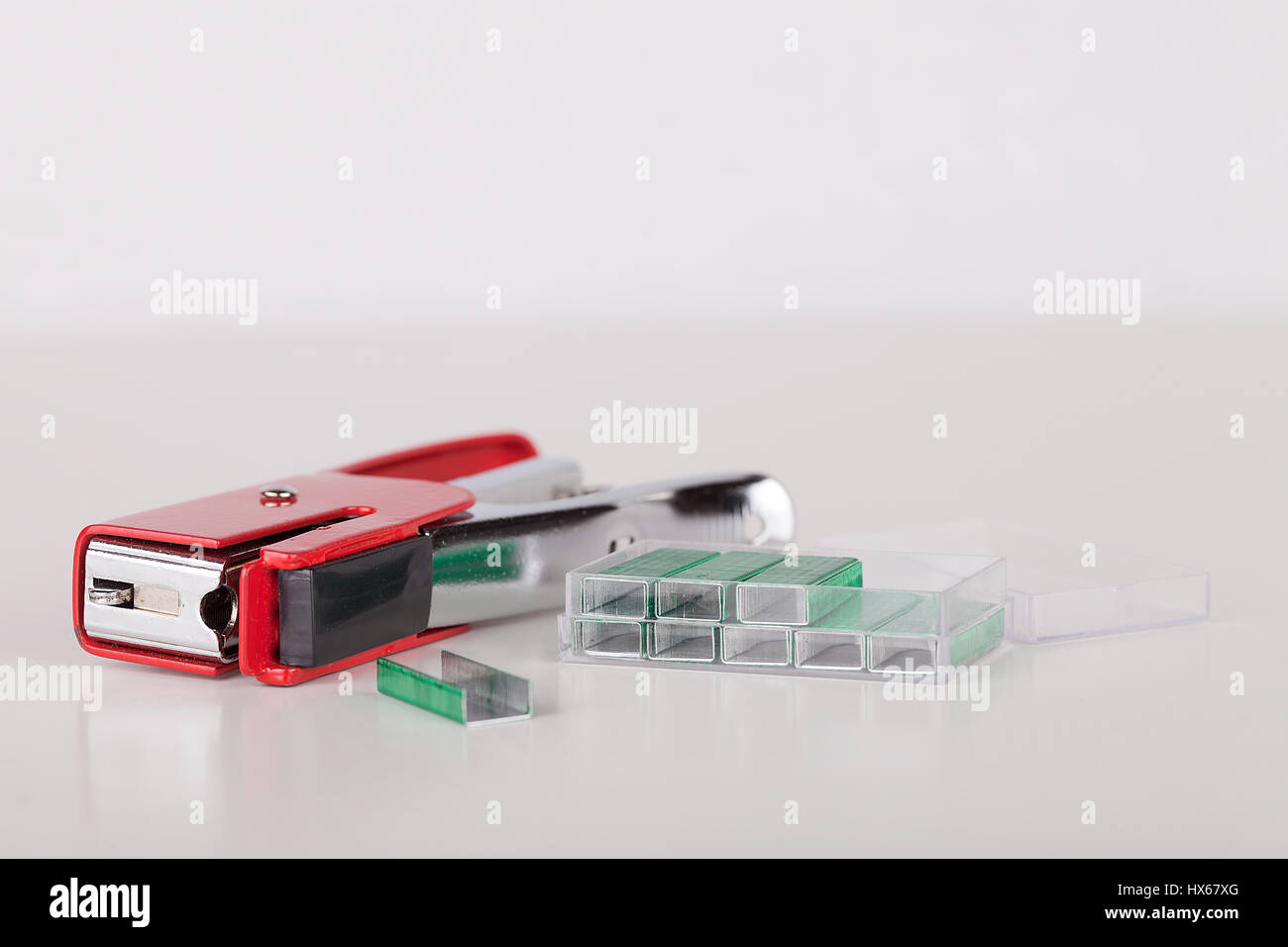 Red stapler and green staples isolated on white background Stock Photo ...