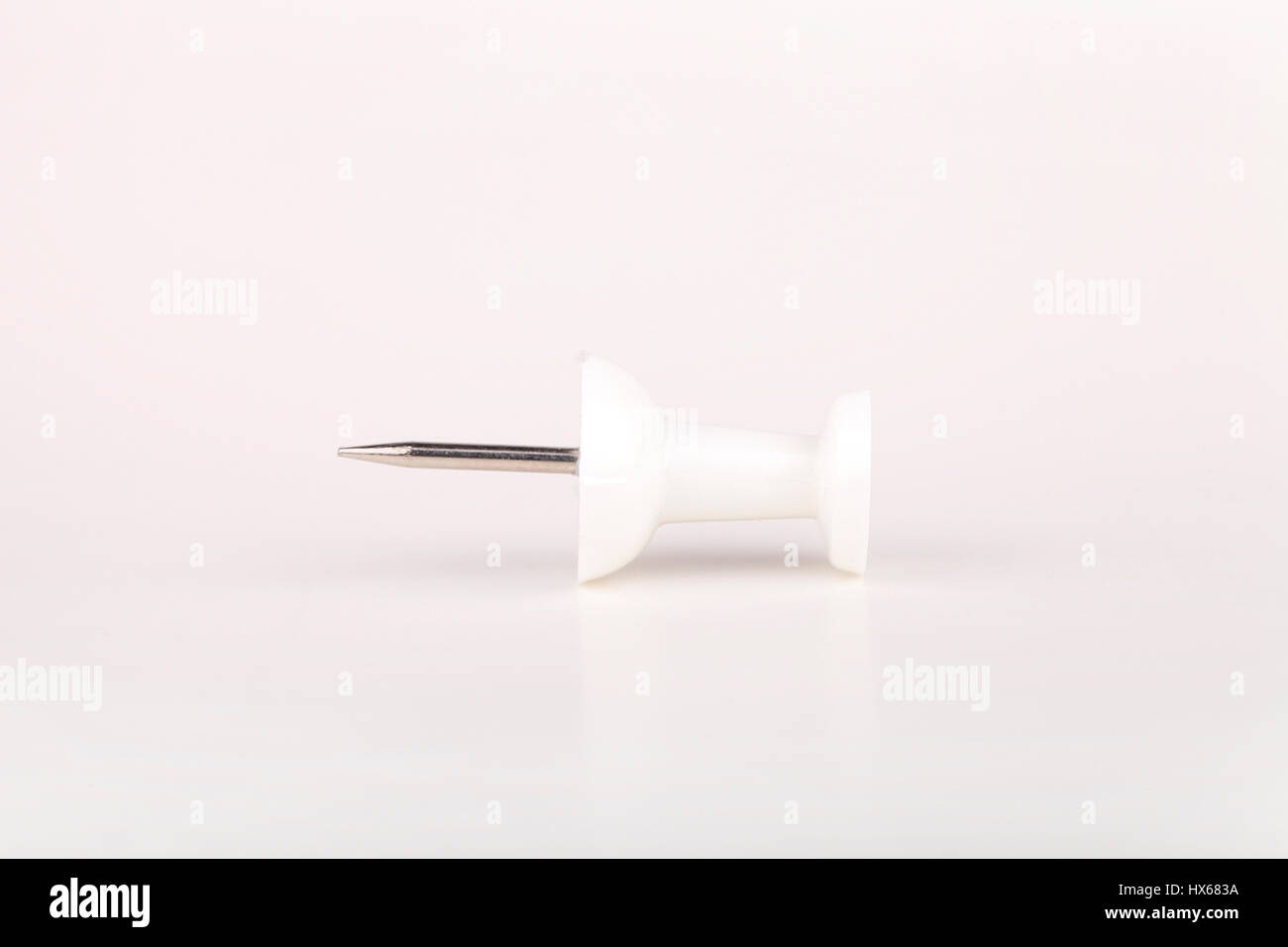 White pushpin on a white surface. Push pin isolated on white background ...