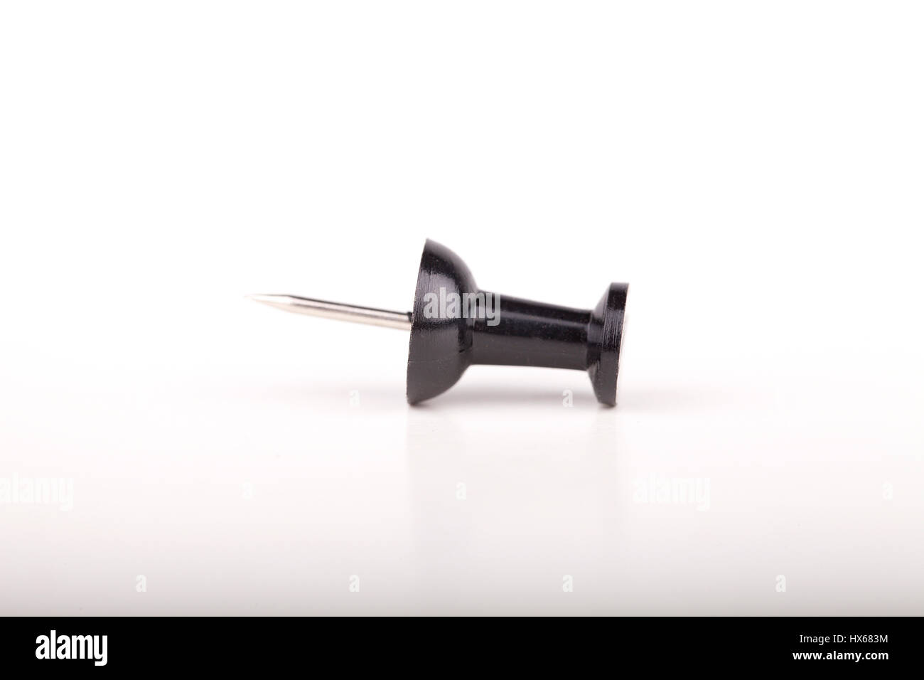 Black pushpin on a white surface. Push pin isolated on white background ...