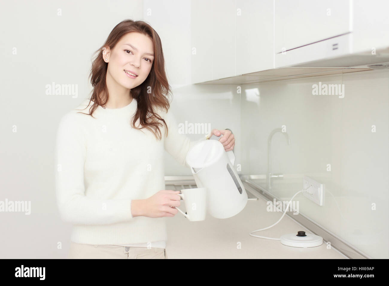 Pretty girl preparing tea in the kitchen Stock Photo - Alamy