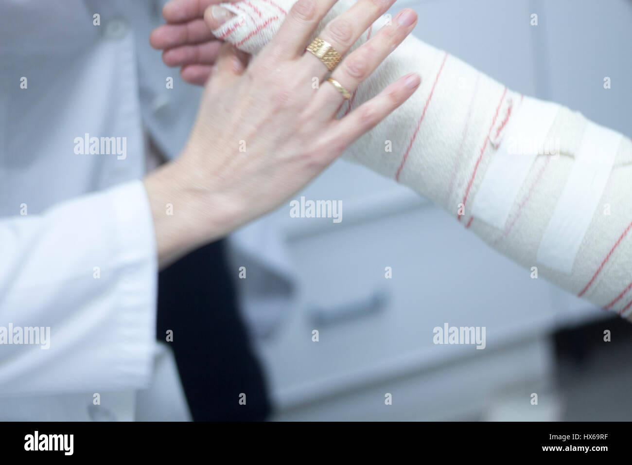 Doctor applying a plaster cast and bandages to patient forearm and ...