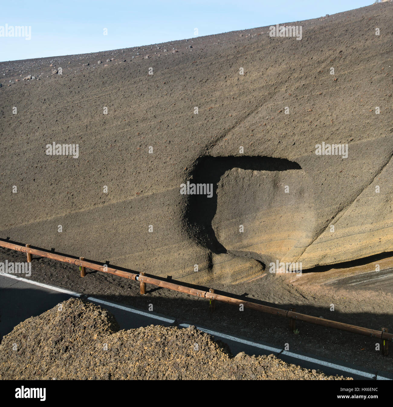 Detail of volcanic rock layers in Tenerife, Spain with a small cave carved into the wall Stock ...