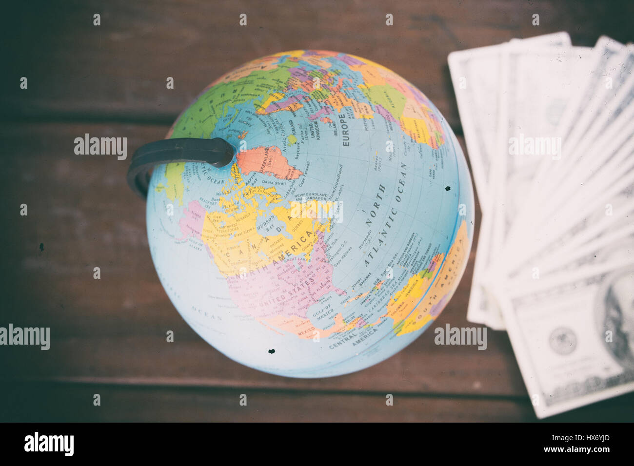 globe with dollar bill on wooden table Stock Photo - Alamy