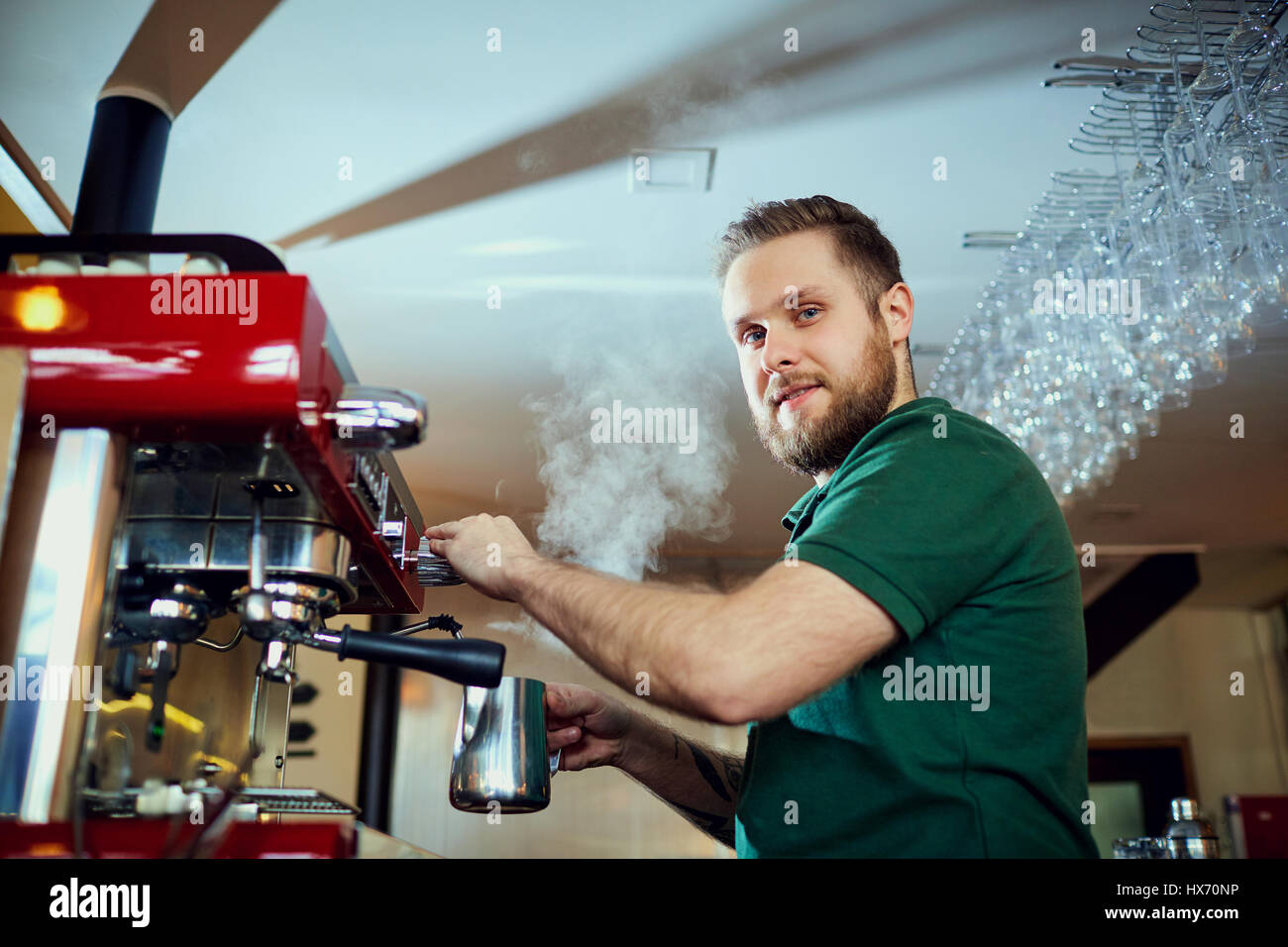 The barman, barista, makes a hot coffee drink at bar counter in Stock ...