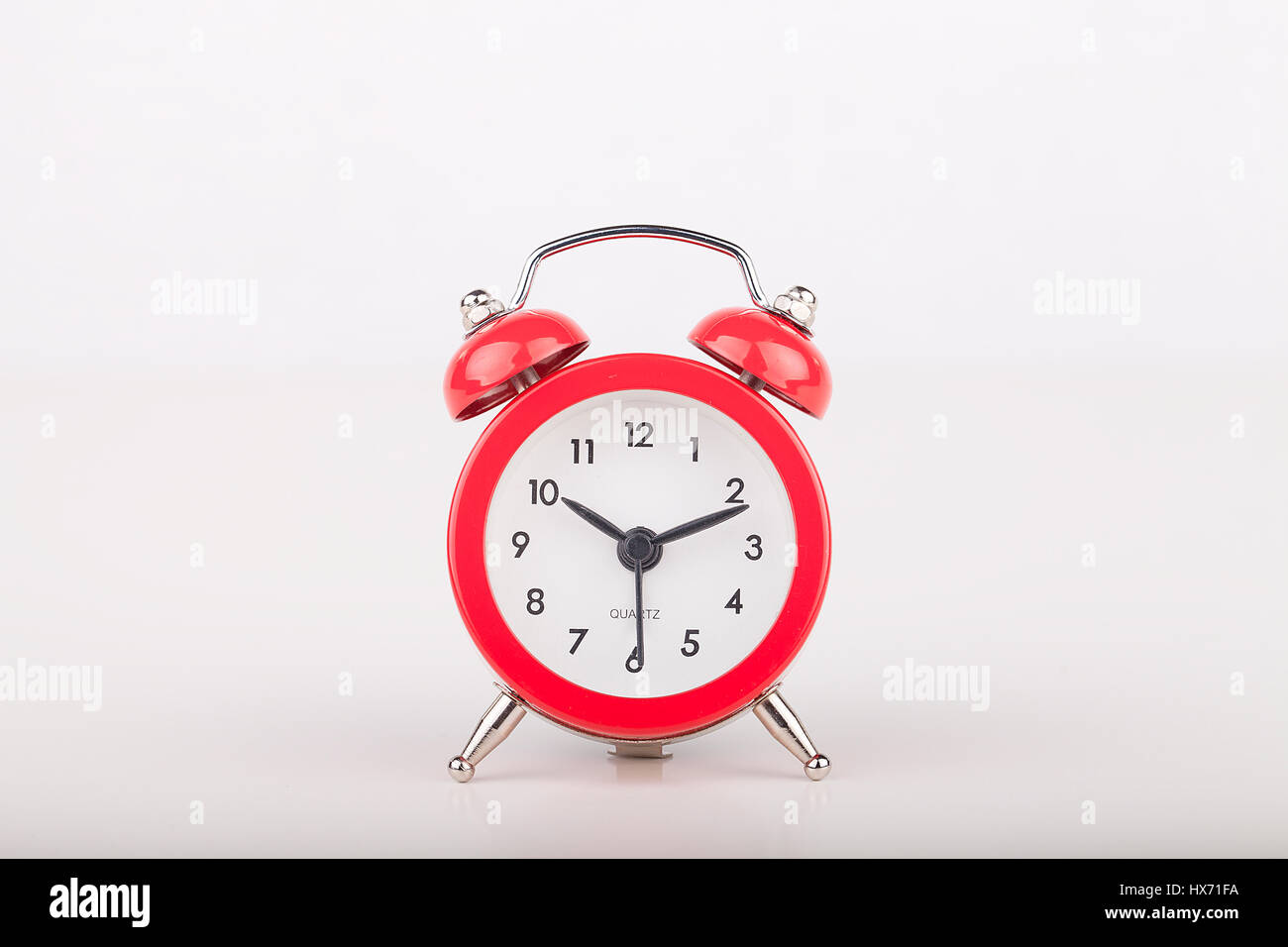 Red alarm clock on a white surface. Bell clock isolated on white ...