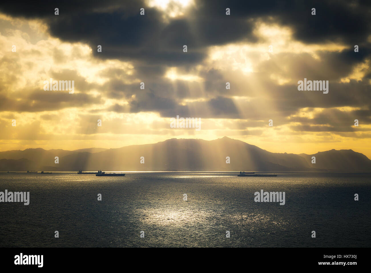 sun rays on the sea with ships Stock Photo - Alamy