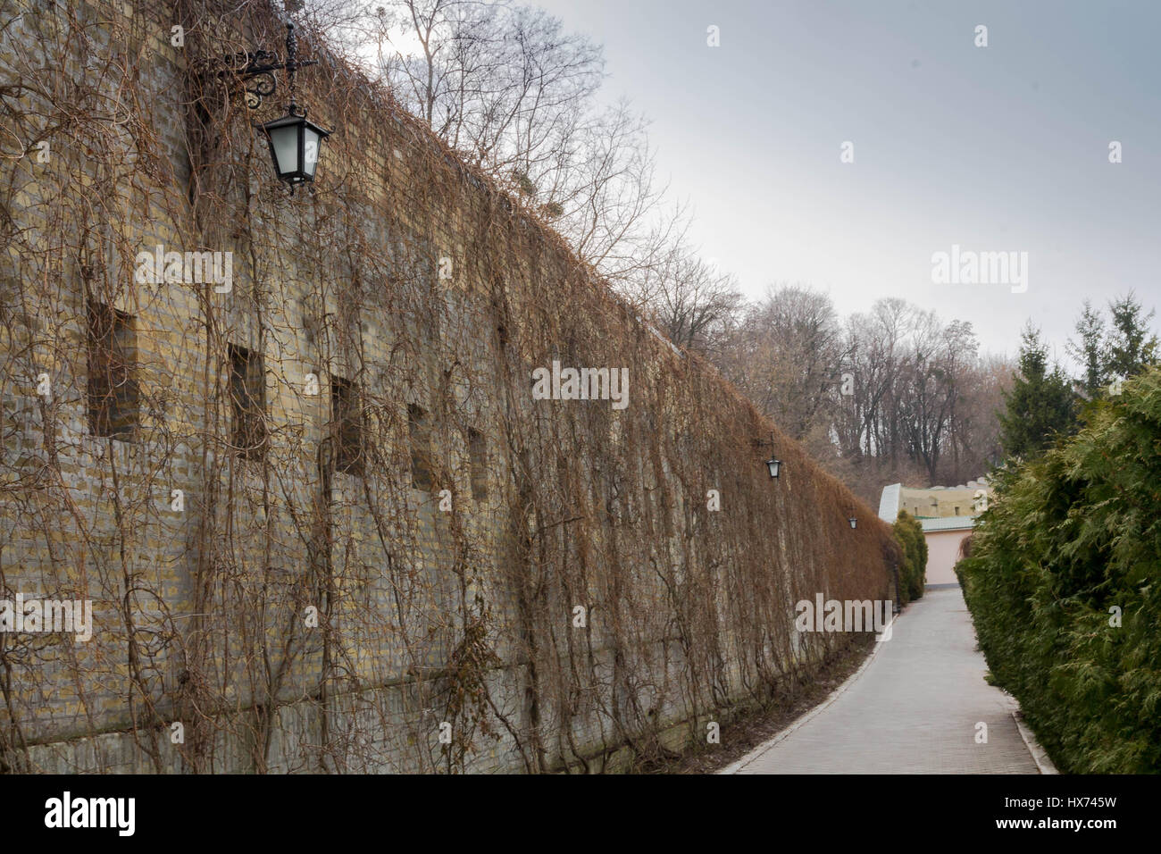 Long alley with brick walls and lanterns Stock Photo - Alamy