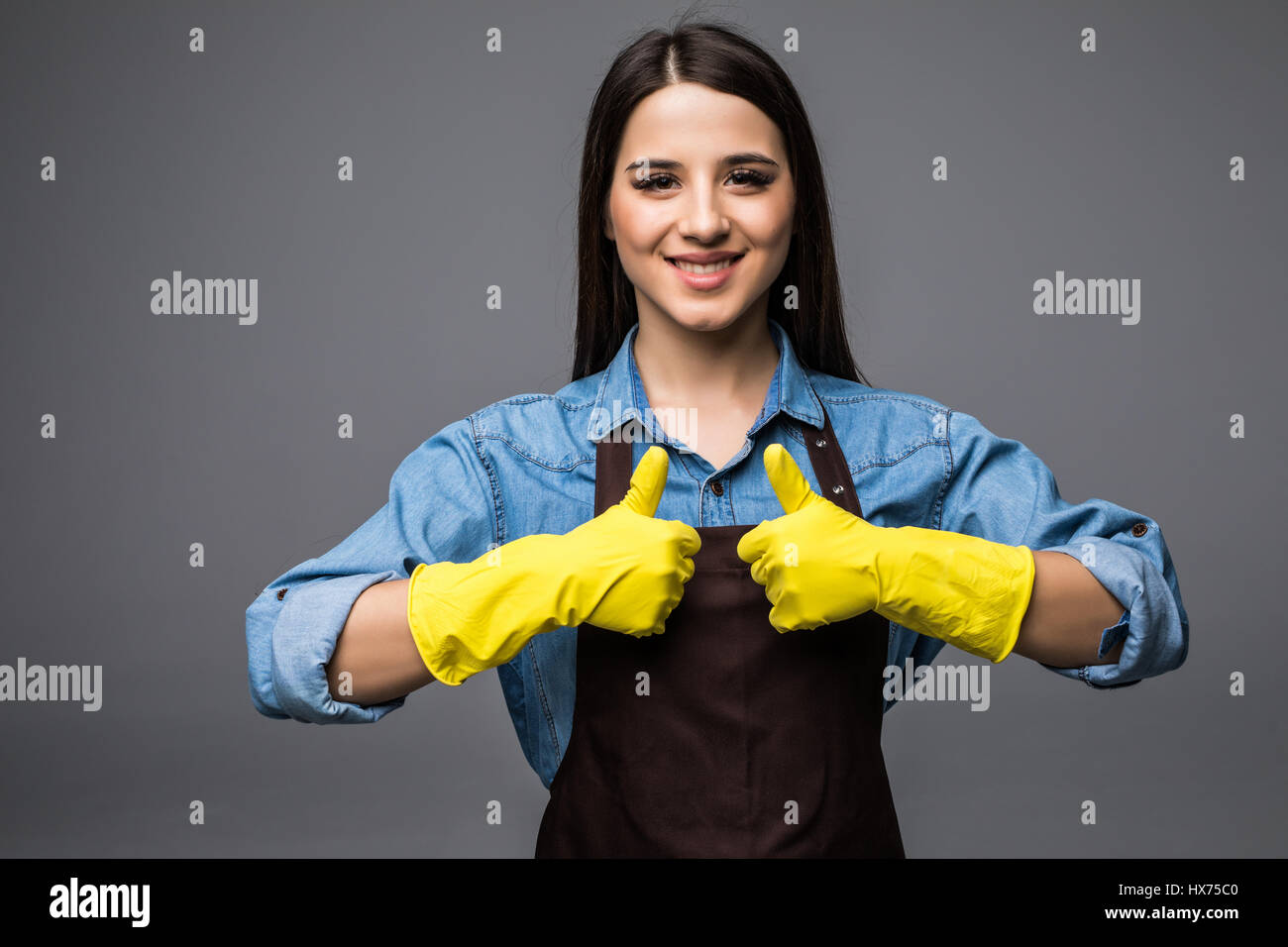Cleaner woman thumbs up with yellow gloves Stock Photo - Alamy