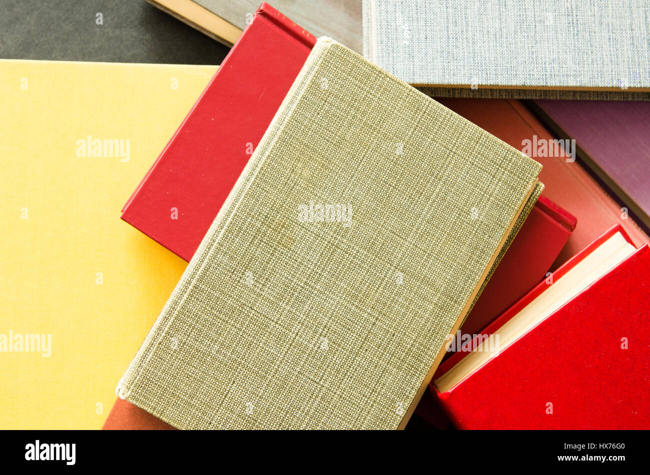 a stack of colorful books in a library or a room Stock Photo - Alamy