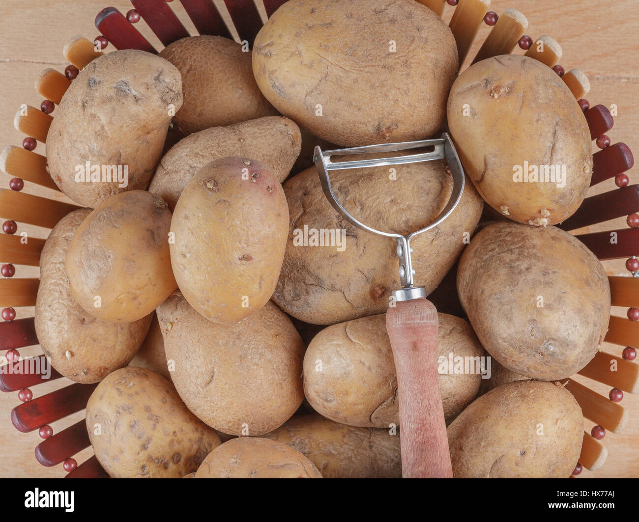Fresh raw rustic farm potatoes in wooden basket next to a handmade ...