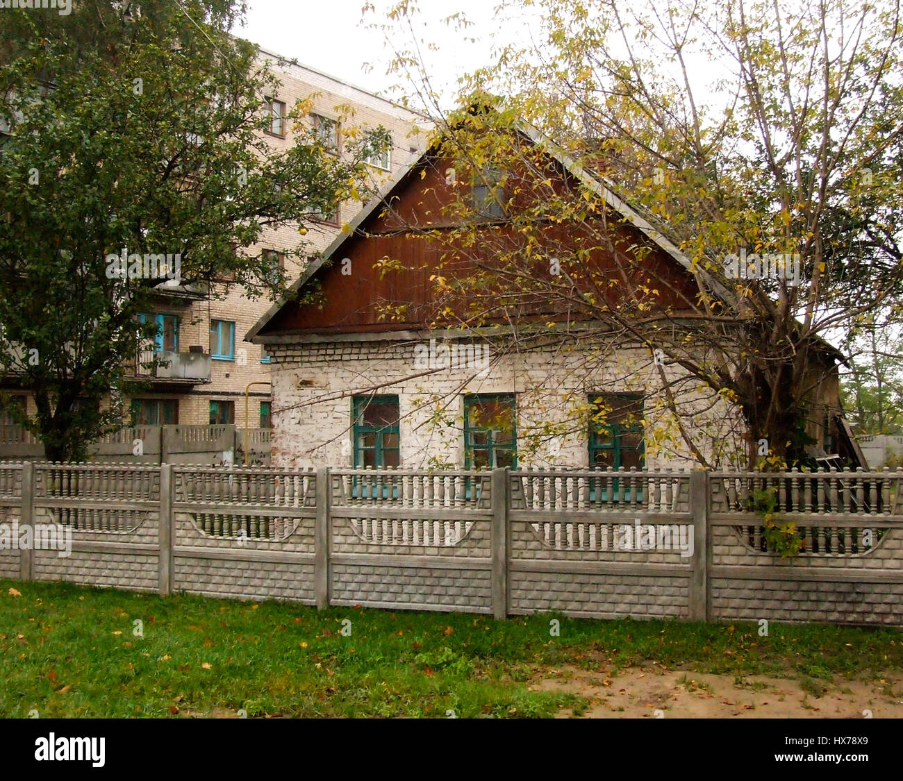 An old brick house beside a Soviet-era multi-story apartment building ...
