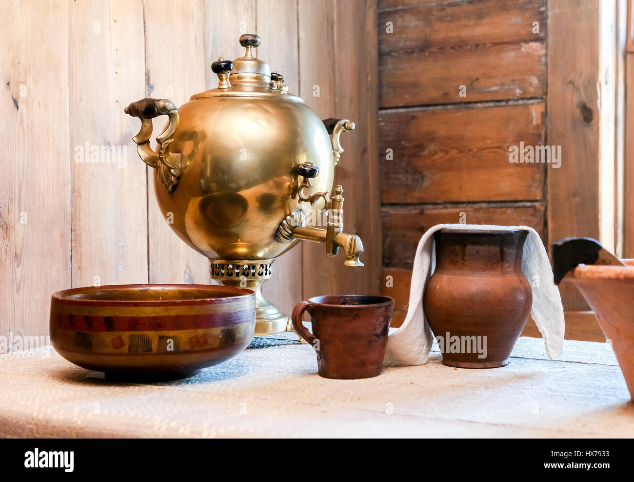 Traditional old copper samovar for tea drinking and ceramic ware on a ...