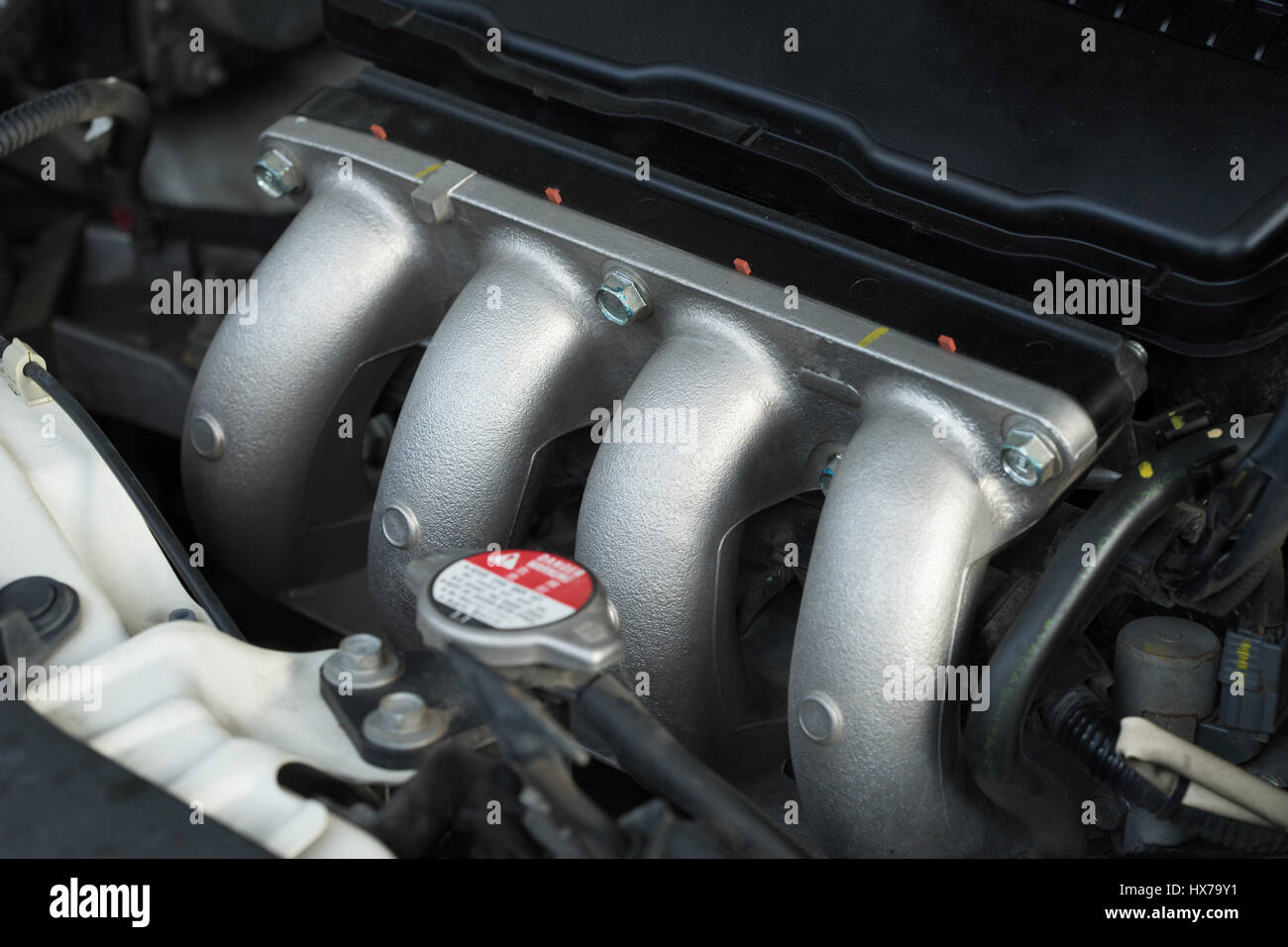 Silver colored car engine with four cylinders Stock Photo - Alamy
