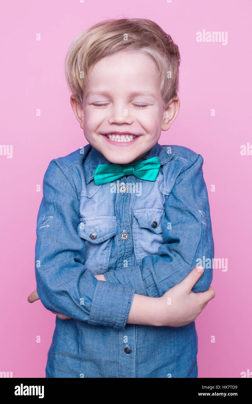 Young handsome kid smiling with blue shirt and butterfly tie. Studio ...