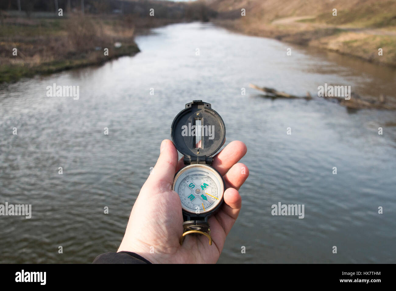Man traveler holding a compass. On the background - beautiful river ...