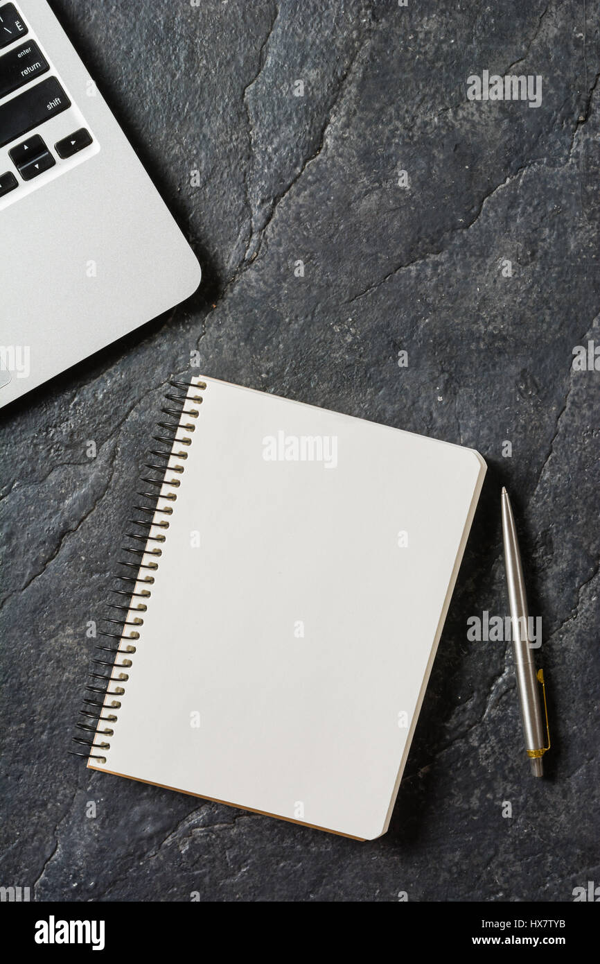 Laptop, pen and notebook with a spring on a black background. Clean ...