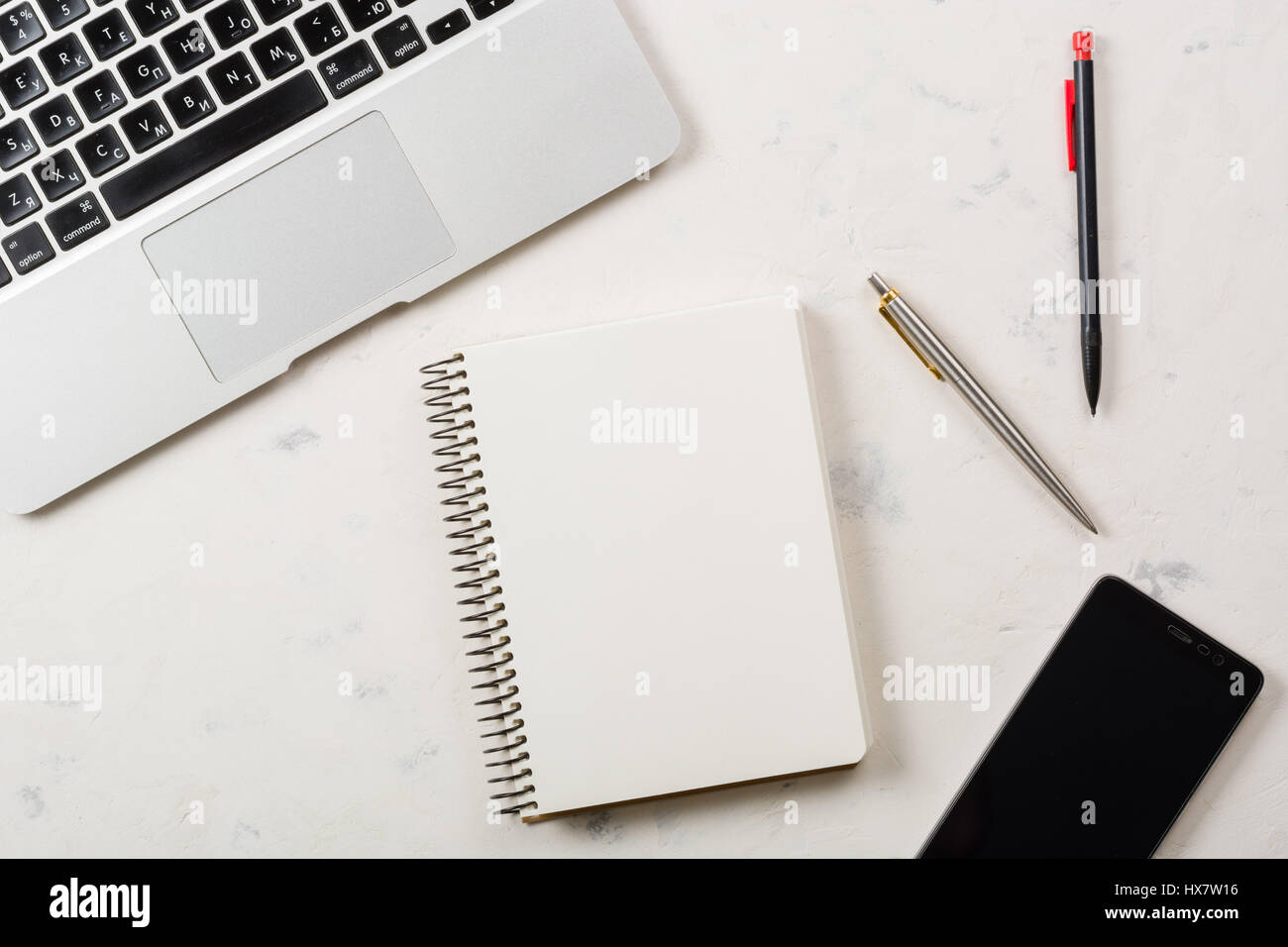 Business background with laptop and notepad on white stone background ...
