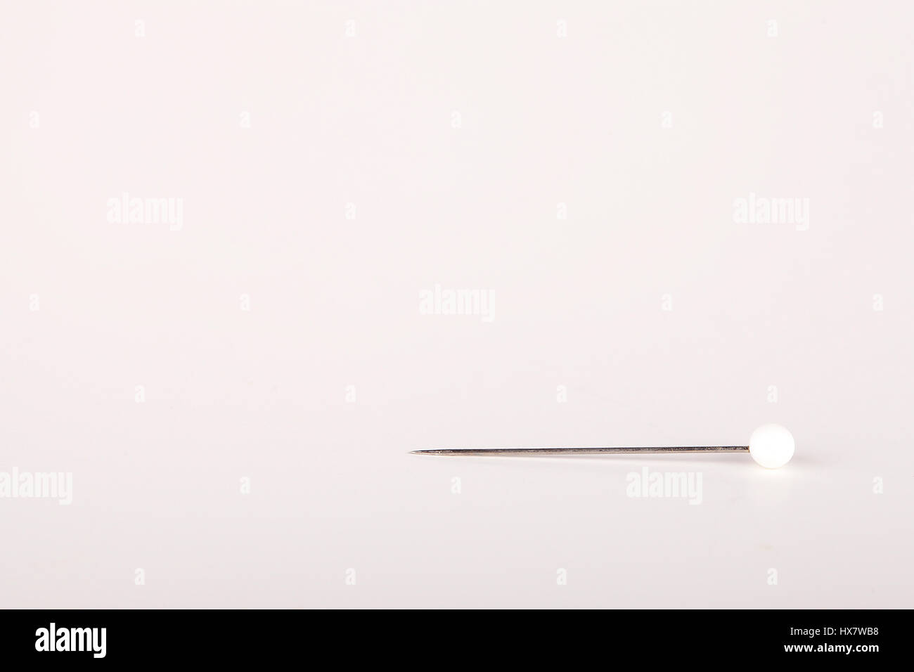 Single white straight pins isolated on white background Stock Photo - Alamy