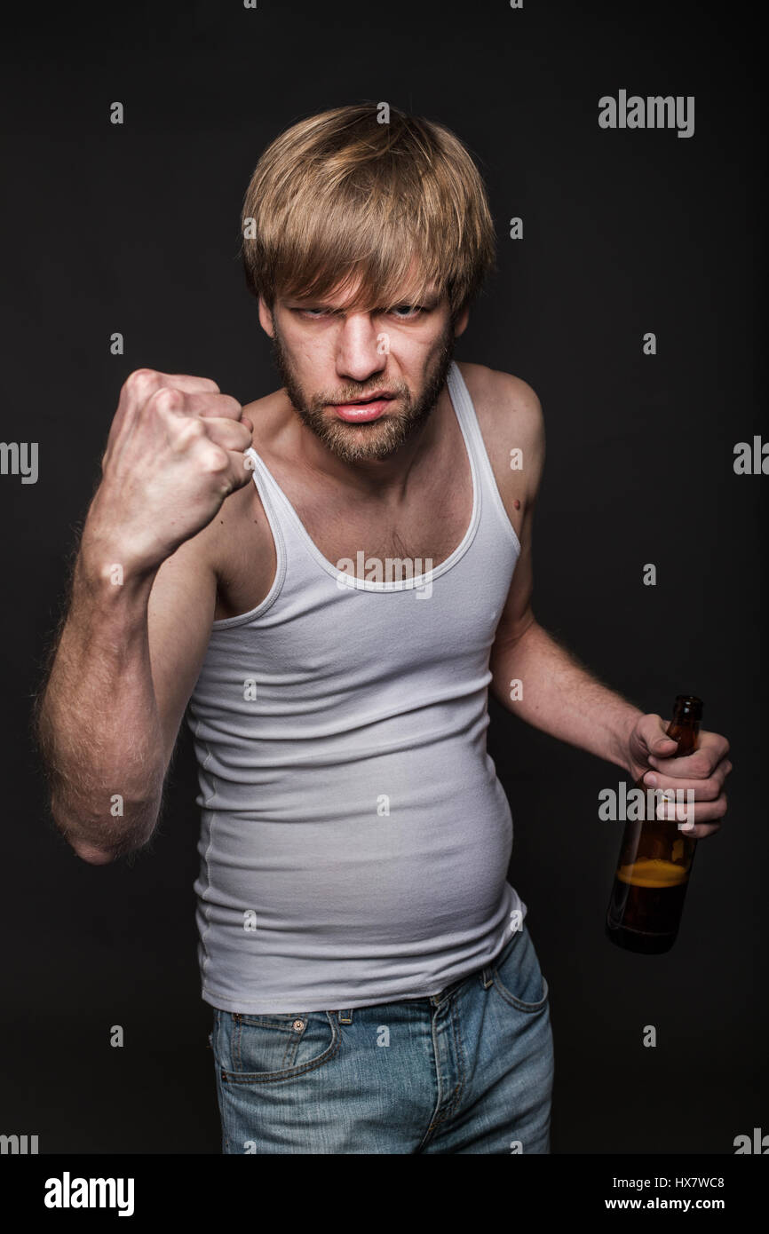 Drunk man threaten with fist. Studio portrait over black background ...