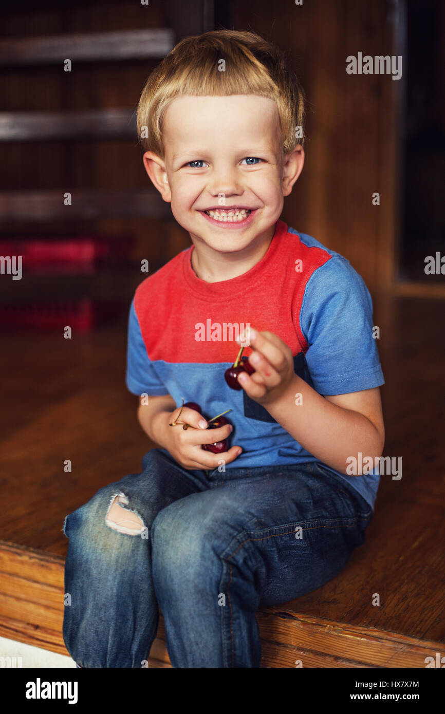 Happy little toddler boy eat berry. Outdoor portrait Stock Photo - Alamy