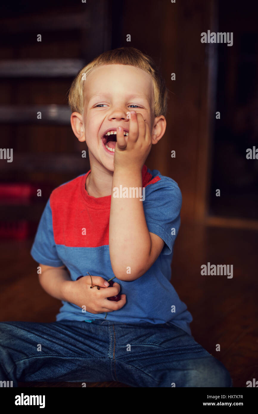Happy little toddler boy eat berry. Outdoor portrait Stock Photo - Alamy