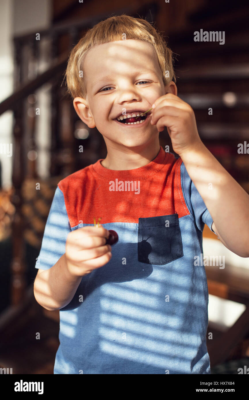 Happy little toddler boy eat berry. Outdoor portrait Stock Photo - Alamy