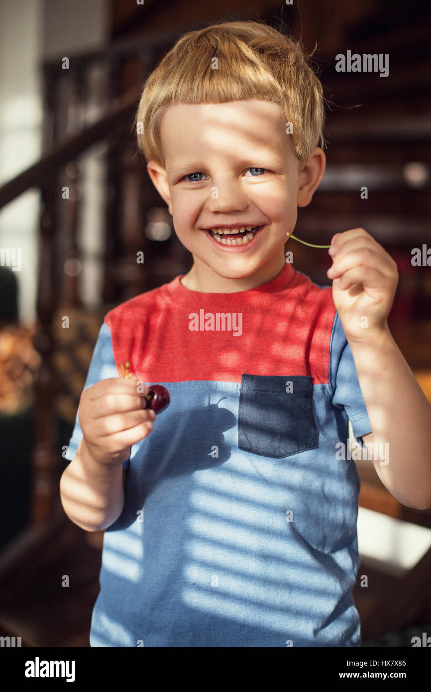 Happy little toddler boy eat berry. Outdoor portrait Stock Photo - Alamy