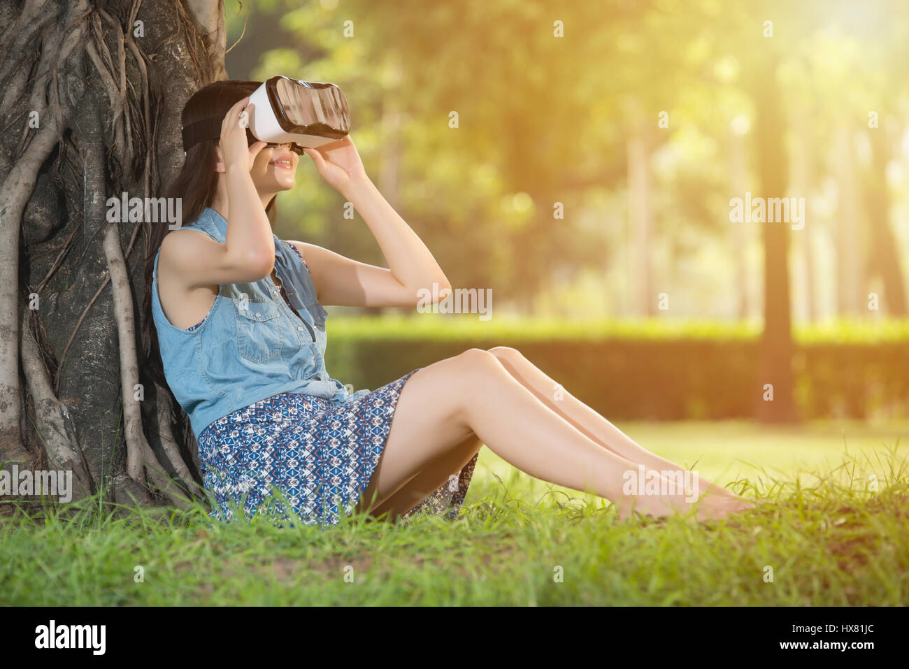 beautiful asian woman experience virtual reality sitting on grass in ...