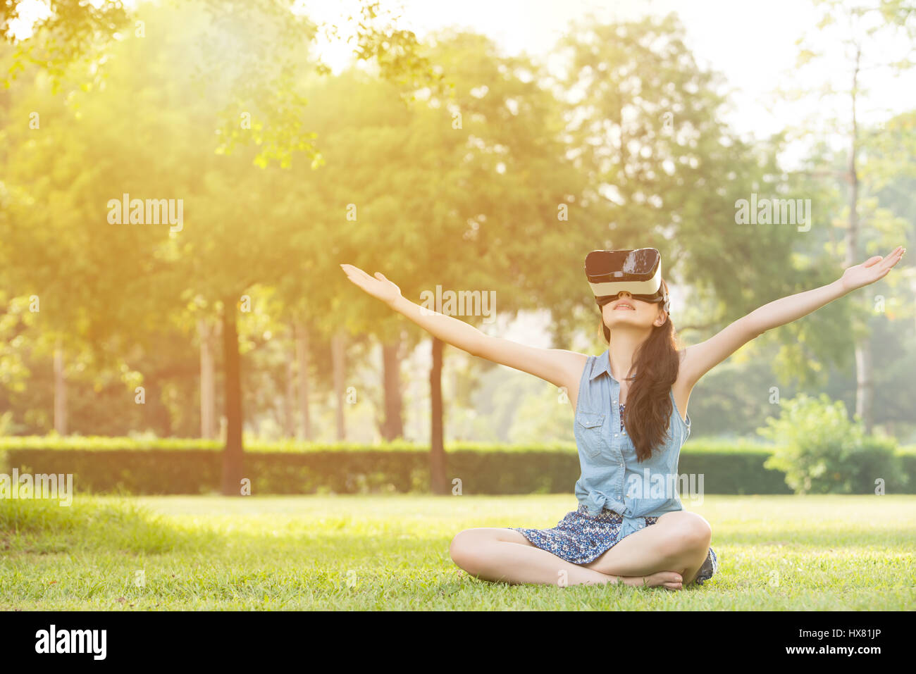 beautiful asian woman enjoy virtual reality sitting on grass in outdoor ...