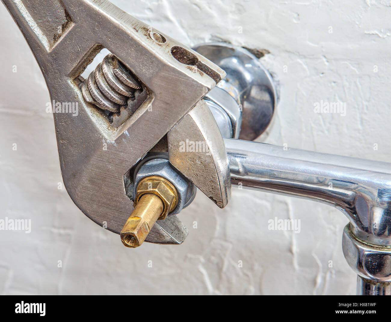 Close-up an adjustable wrench plumbers fixes the valve for water faucet ...