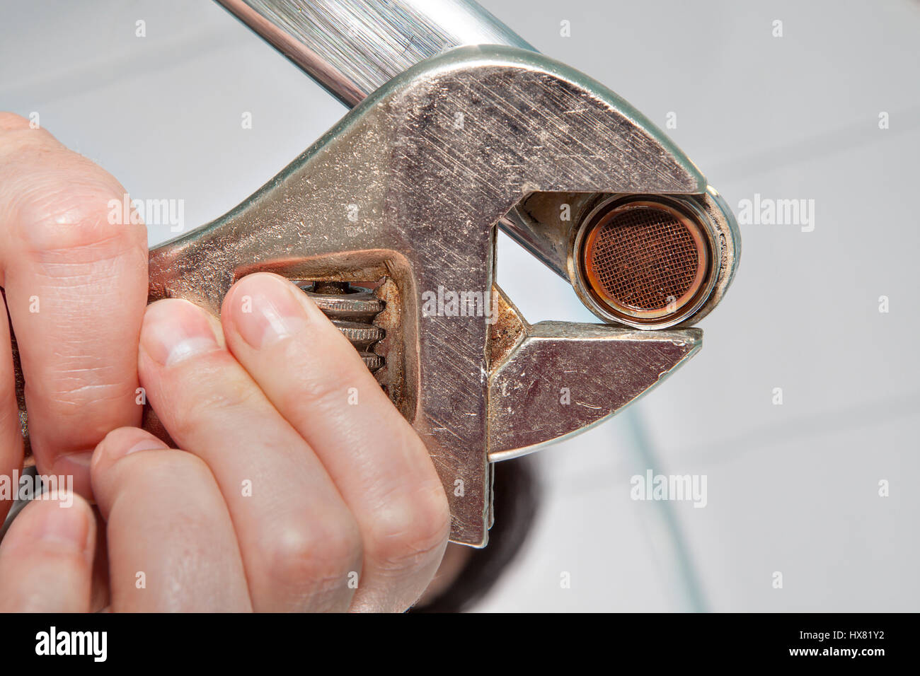 Remove the old aerator from the faucet with an adjustable wrench, close ...