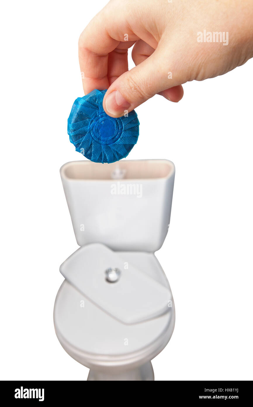 Close-up of hand pushes blue cleaning tablet into the toilet bowl drain ...