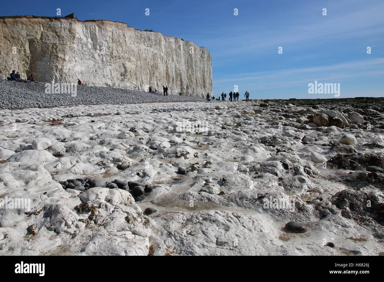 A big group of people in the distance with white chalk Sussex cliffs in ...