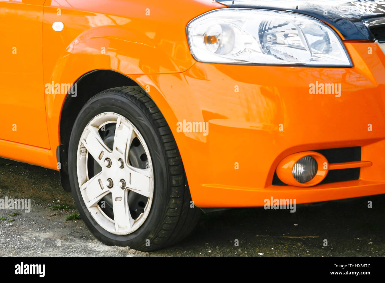 Wing, wheel and car headlight bright color, close-up Stock Photo - Alamy