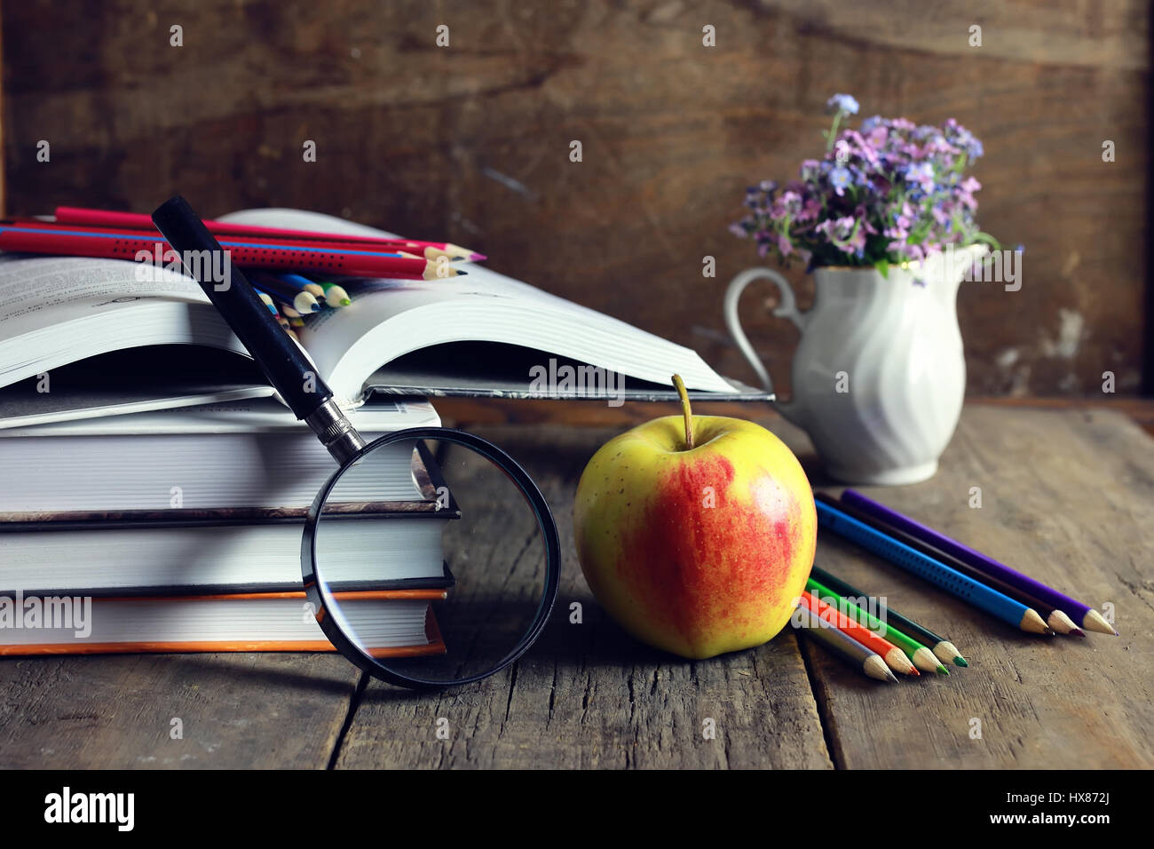 education book apple and magnifying glass Stock Photo - Alamy