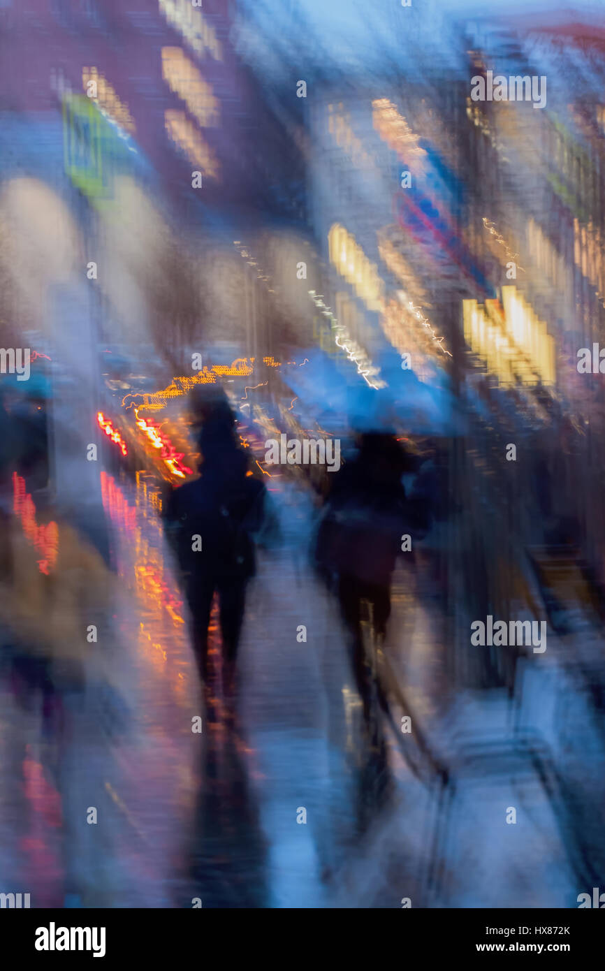 Abstract background of blurred people figures under umbrellas, city ...