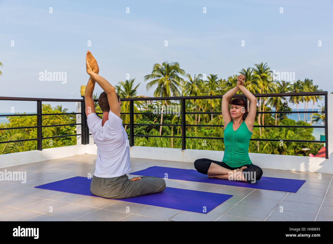 Yoga instructor conducts classes with the woman on the balcony of the ...