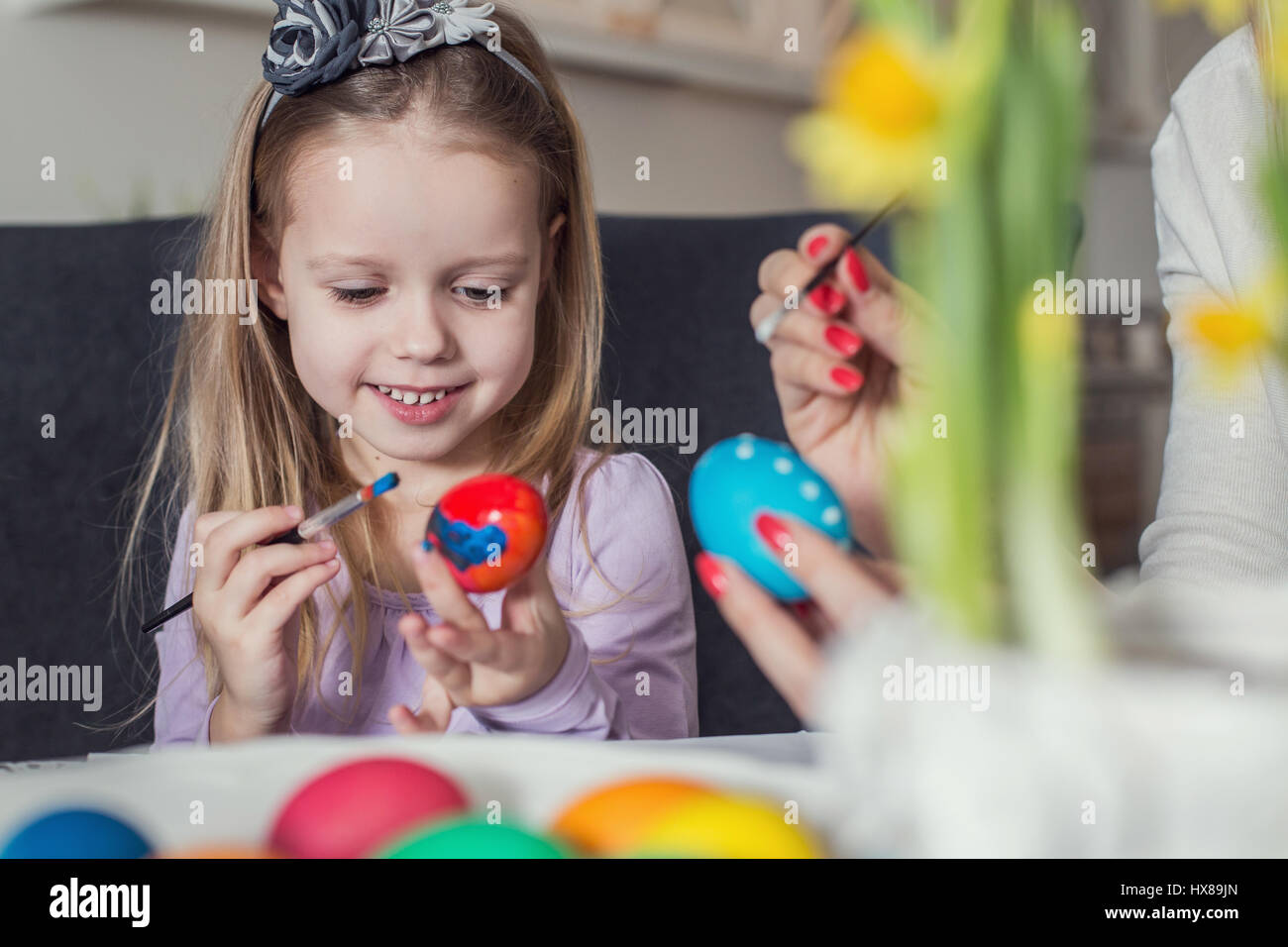 A happy little child coloring easter eggs. Cozy home atmosphere. Easter ...