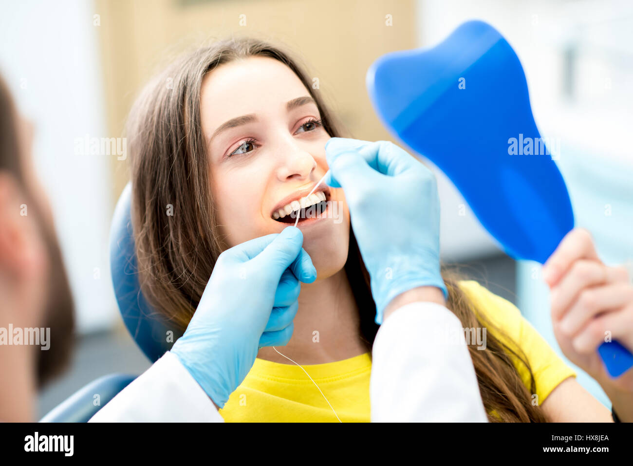 Professional teeth cleaning with dental floss at the dental office ...