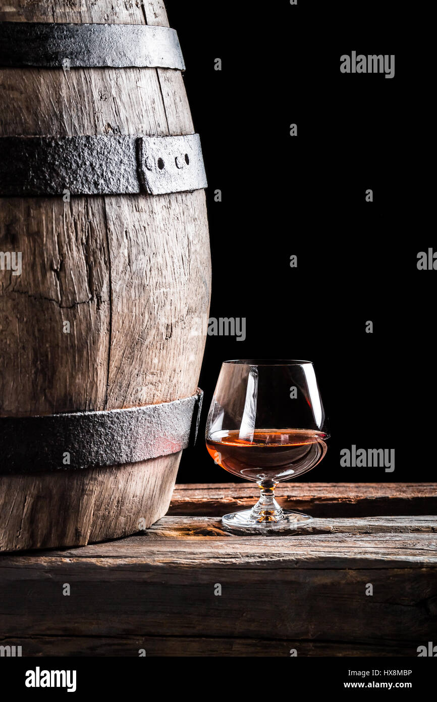 Glass of cognac and old oak barrel Stock Photo - Alamy