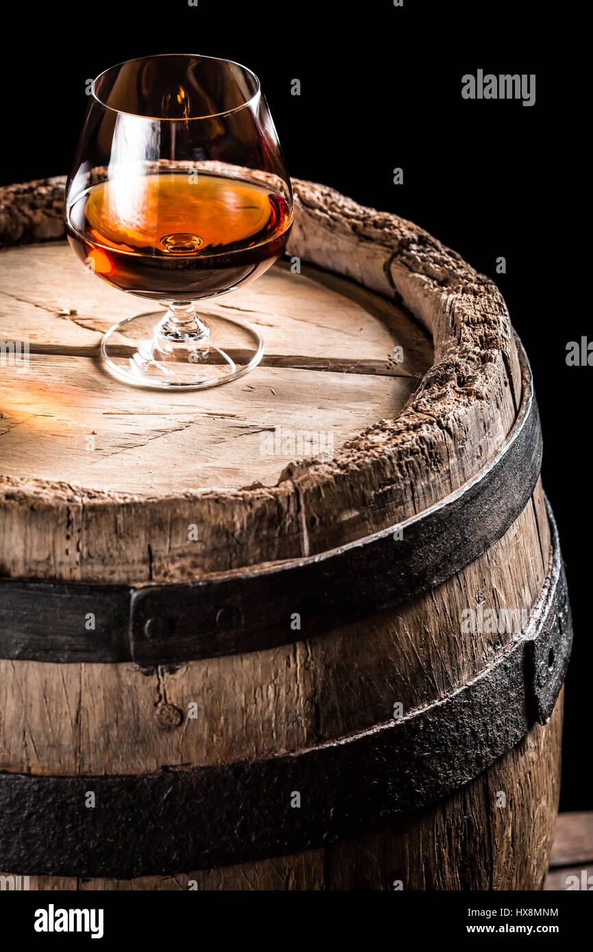 Glass of aged cognac and old wooden barrel Stock Photo - Alamy