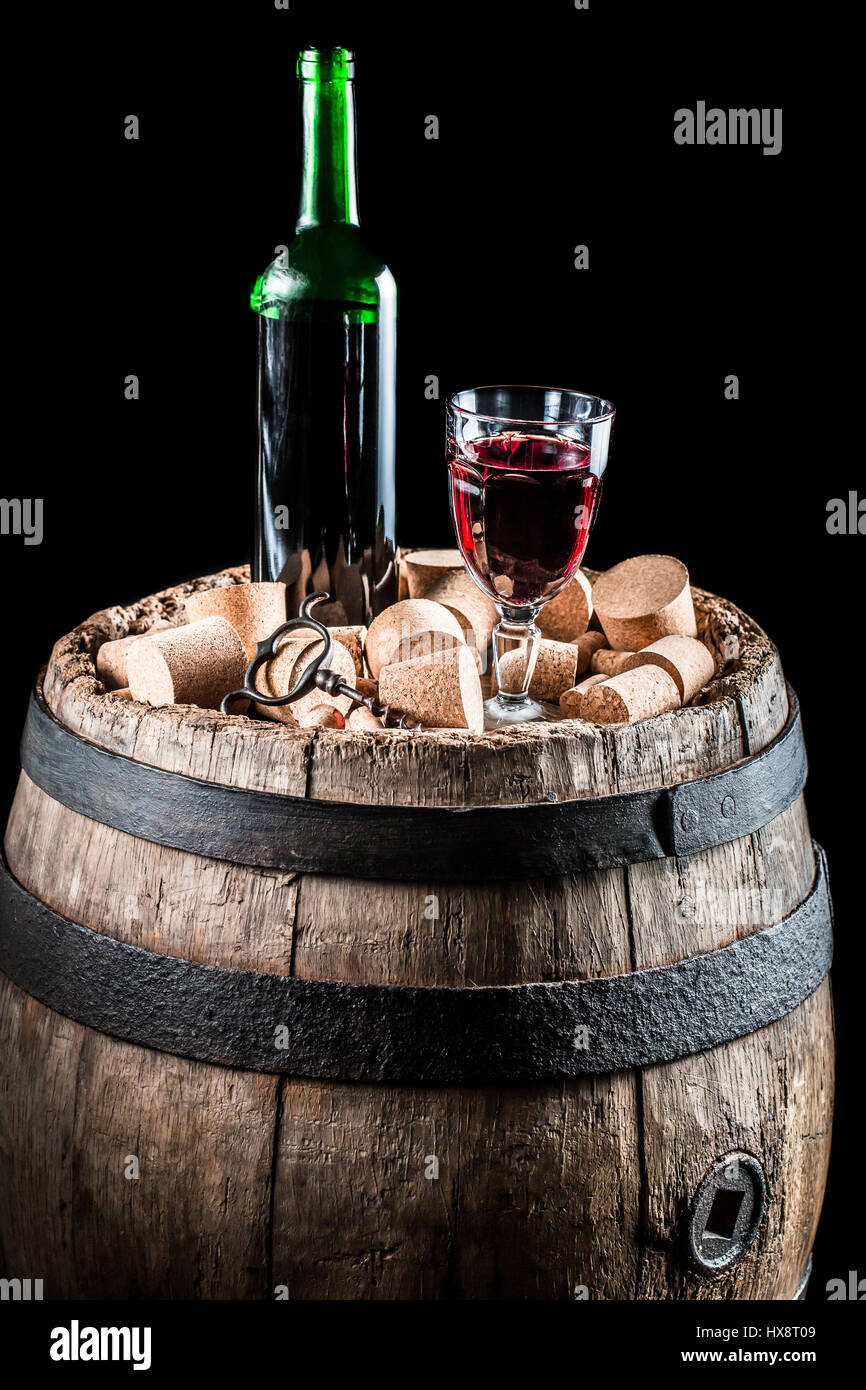 Glass of red wine and a bottle standing on a barrel Stock Photo - Alamy
