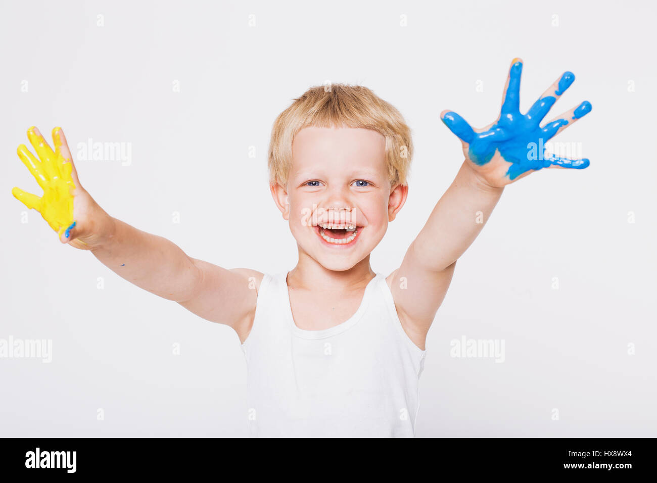 Boy with hands painted in colorful paints ready to make hand prints ...