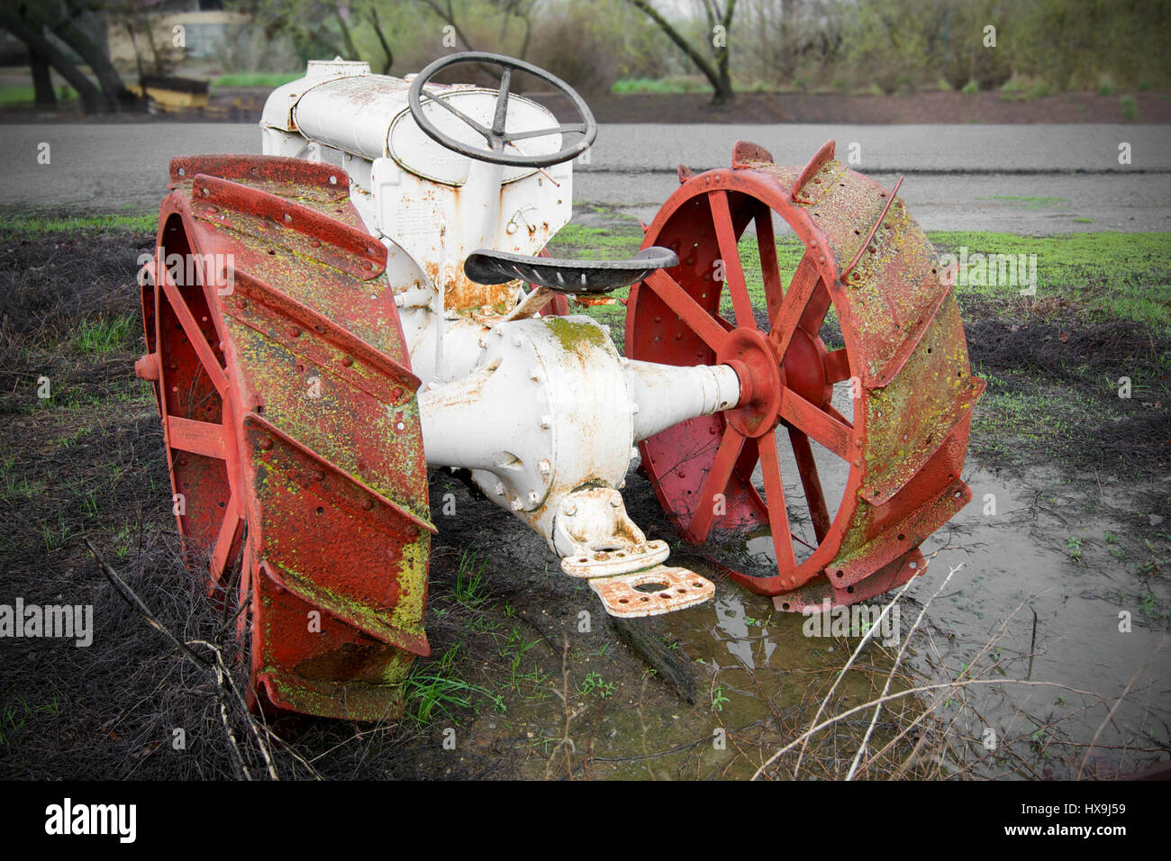 Old white Fordson tractor rusting away in old farm equipment graveyard ...