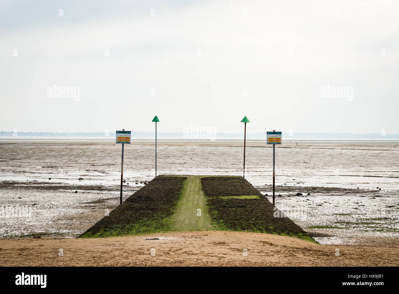 Essex beach with sand leading onto to a seaweed covered jetty or slip ...