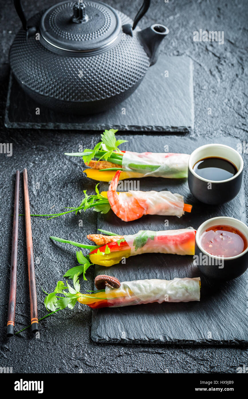 Closeup of spring rolls with vegetables on black rock Stock Photo - Alamy