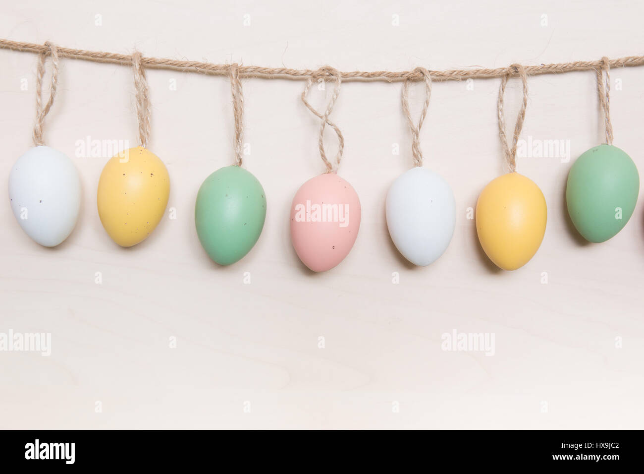 Colorful Easter eggs hanging on rope over wooden background Stock Photo ...
